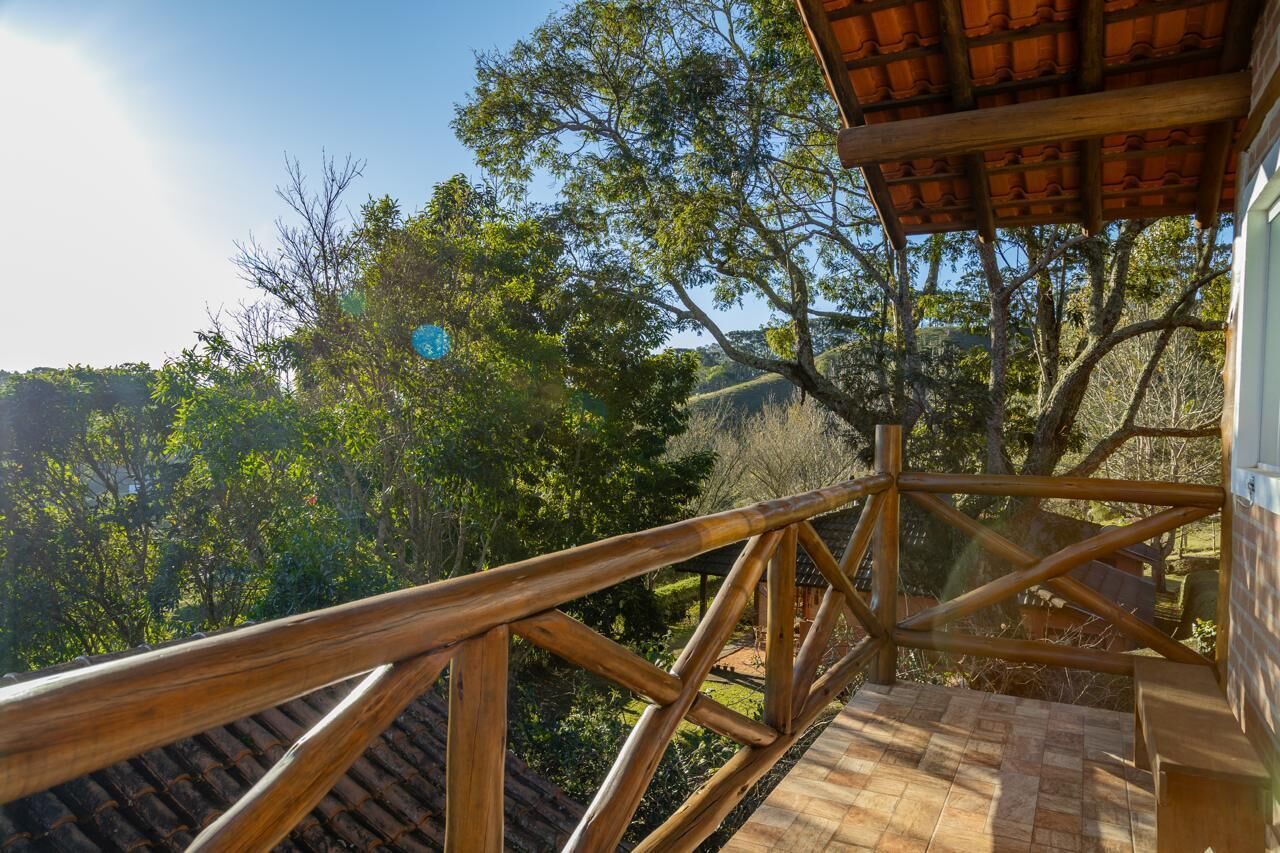 Um deck de madeira com vista para uma paisagem acidentada e árvores.