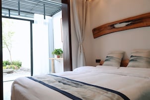 Quarto com cama, cortinas, uma planta e vista para o exterior.