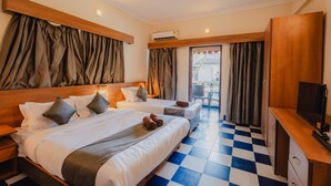 Quarto de hotel com duas camas, televisão e varanda com vista.