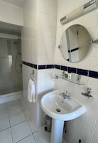 Quarto casal, vista parcial para o mar | Banheiro | Chuveiro, produtos de toalete grátis, secador de cabelo