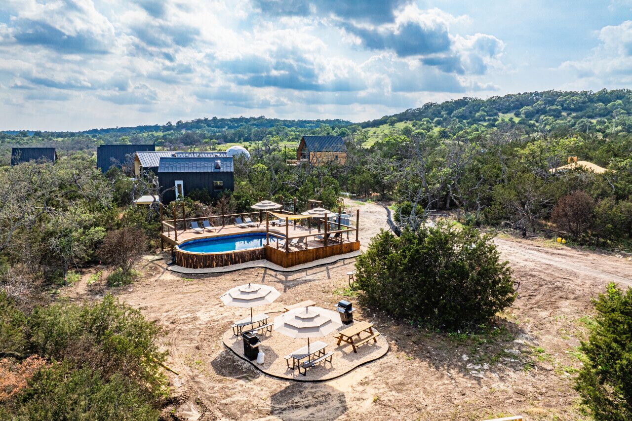 Um resort com piscina, área de estar ao ar livre e vista para a paisagem circundante.