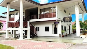 Um edifício de dois andares com varanda, escadaria e uma placa com a inscrição 'Ticoma Villa'.