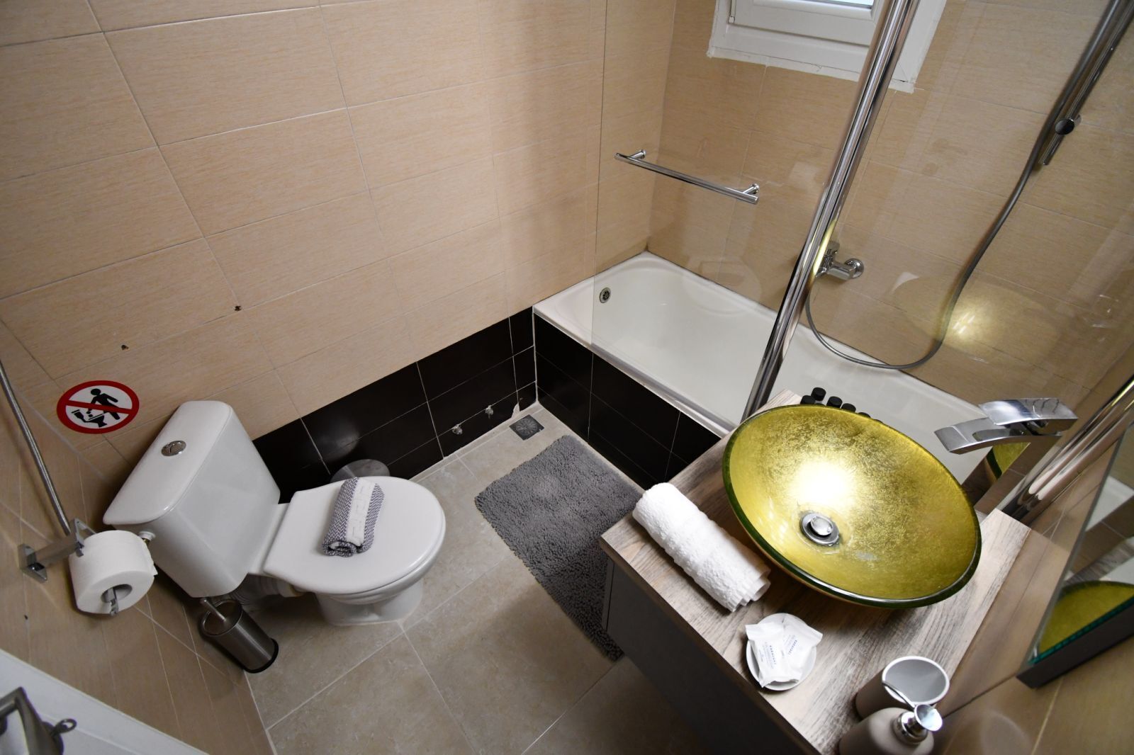 Uma casa de banho moderna com sanita, lavatório e chuveiro.