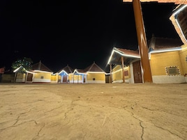 Um pátio com vários edifícios, cada um com telhado de telhas e uma entrada central.