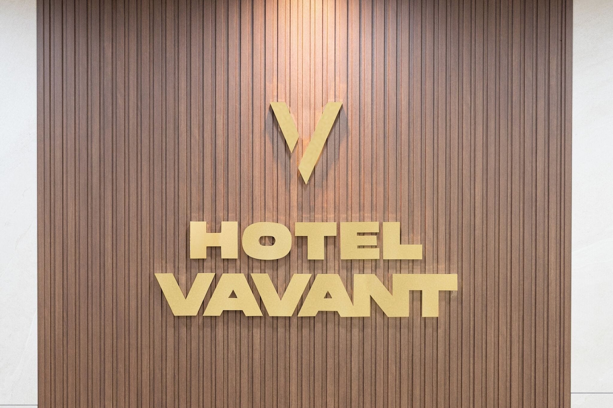 Parede de madeira com uma placa que diz "HOTEL VAVANT".