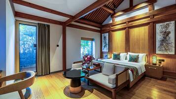 Um quarto com cama, sofá, mesa de jantar e uma cadeira.
