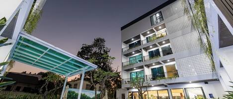 Um hotel moderno com piscina, área de estar externa e espaço coberto.