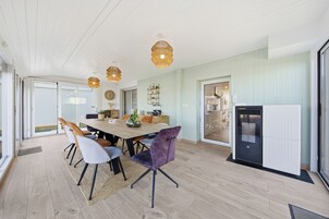 Cozinha moderna com área de refeições, piso de madeira e geladeira.