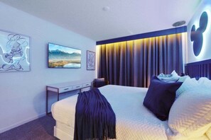Quarto de hotel moderno com uma cama grande, TV de tela plana e vista para as montanhas.
