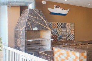 Uma cozinha com forno embutido, decoração náutica pendente e azulejos estampados.