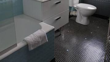 Um banheiro com banheira, pia e vaso sanitário.