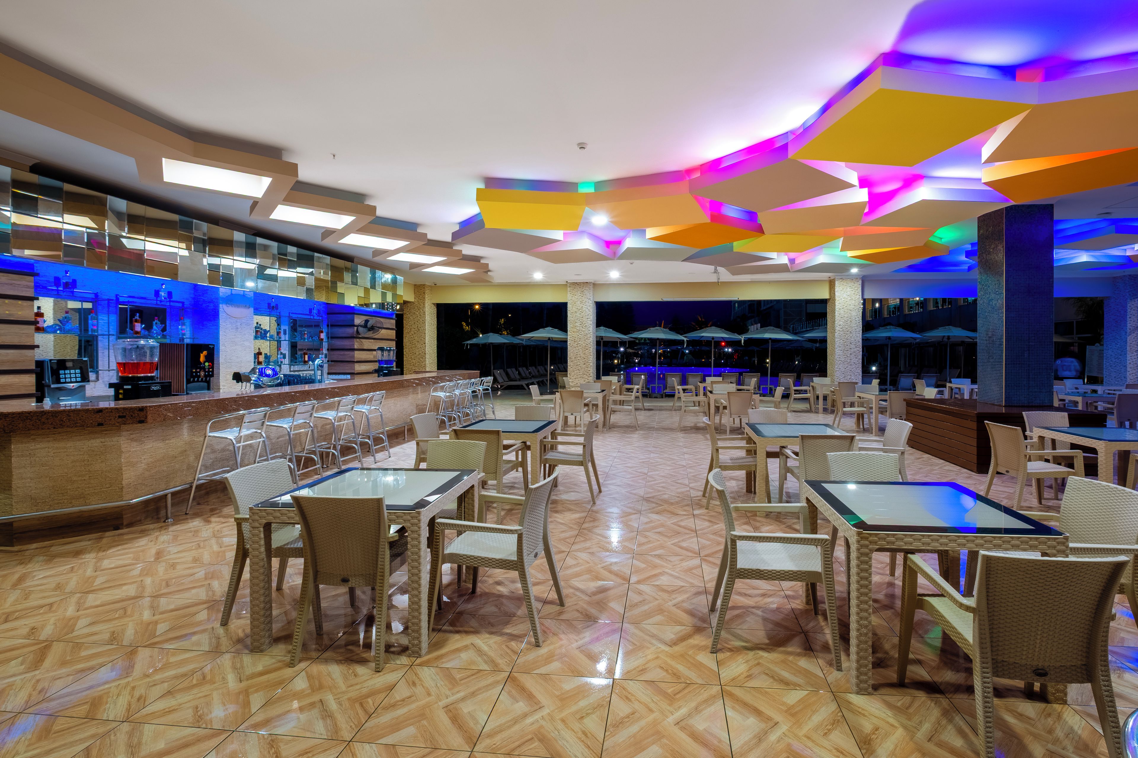 Restaurante com área de bar, diversas opções de assento e vista para o exterior.