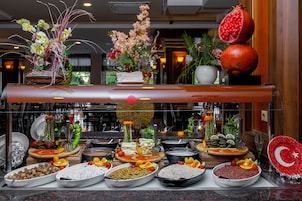 Buffet com diversos pratos e um vaso de planta.
