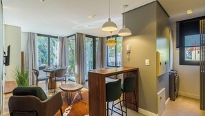 Uma sala de estar moderna com uma mesa de jantar de madeira, dois banquetes e um candelabro.
