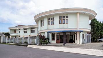Um edifício moderno com fachada curva, várias janelas e entrada coberta.