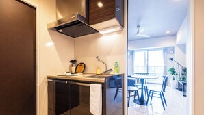 Cozinha moderna com armários escuros, uma coifa de aço inoxidável e uma toalha branca pendurada na porta do forno.