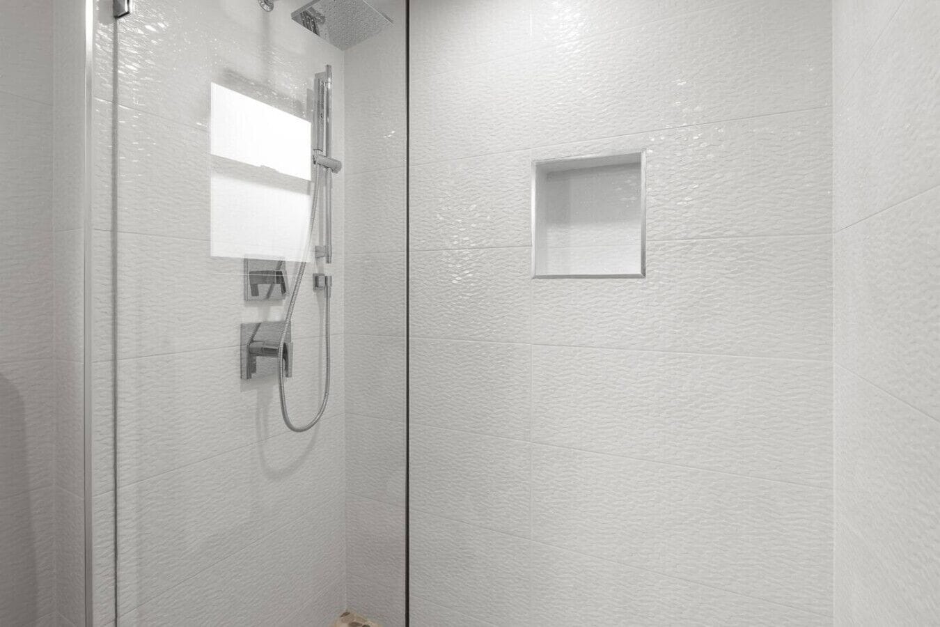 Um chuveiro moderno com um chuveiro manual e um painel de controle fixado na parede.