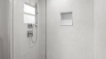 Um chuveiro moderno com um chuveiro manual e um painel de controle fixado na parede.