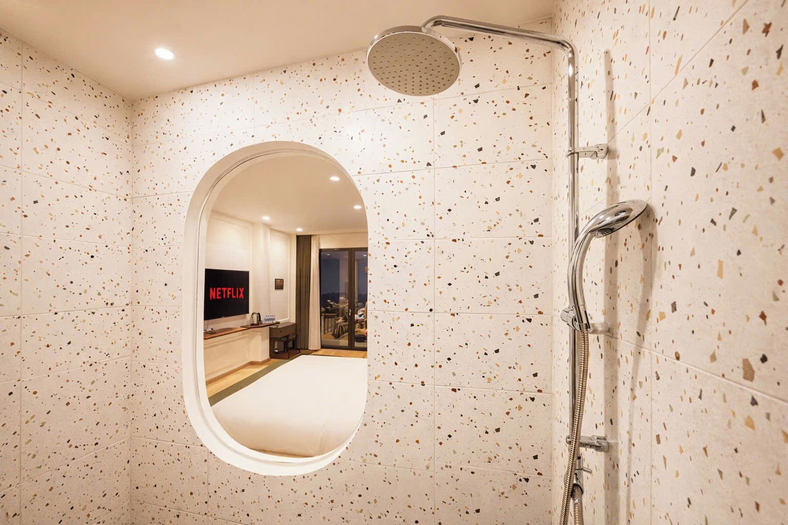 Casa de banho moderna com chuveiro, lavatório e espelho.