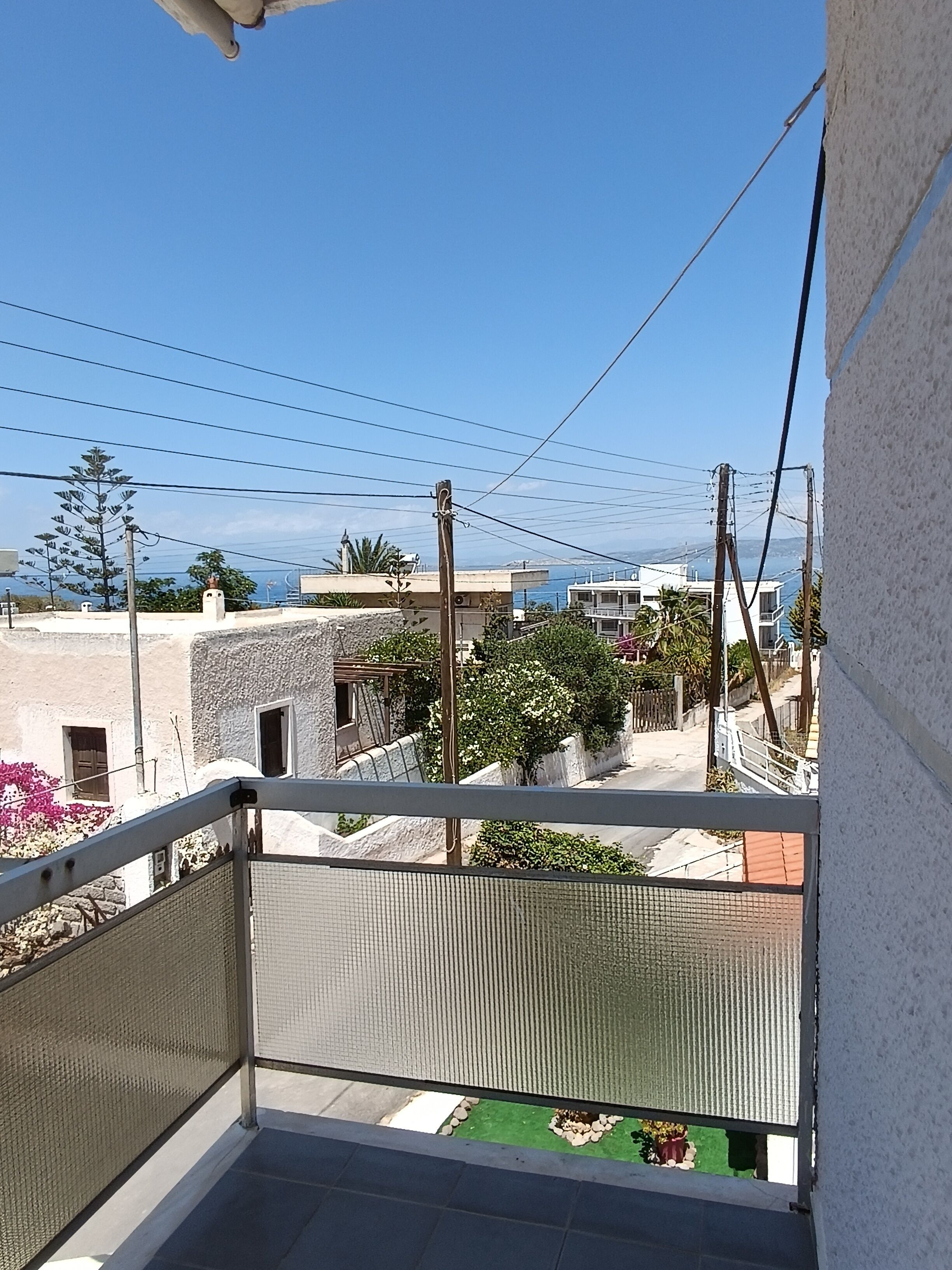 Varanda com vista para uma área residencial, incluindo casas e uma costa distante.