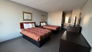 Quarto de hotel com duas camas, uma mesa e um espelho.