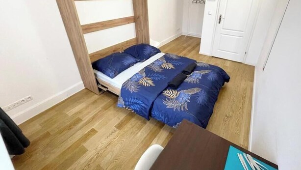 Um quarto pequeno e compacto com uma cama, uma mesa e uma cadeira.