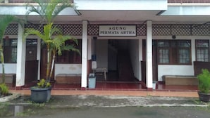 Um edifício com uma placa que diz 'AGUNG PERMATA ARTHA'.