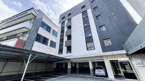 Um hotel moderno com um átrio central, vários andares e área de estacionamento.