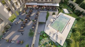 Vista aérea de um edifício moderno com piscina no terraço, áreas de estar ao ar livre e jardins ajardinados.