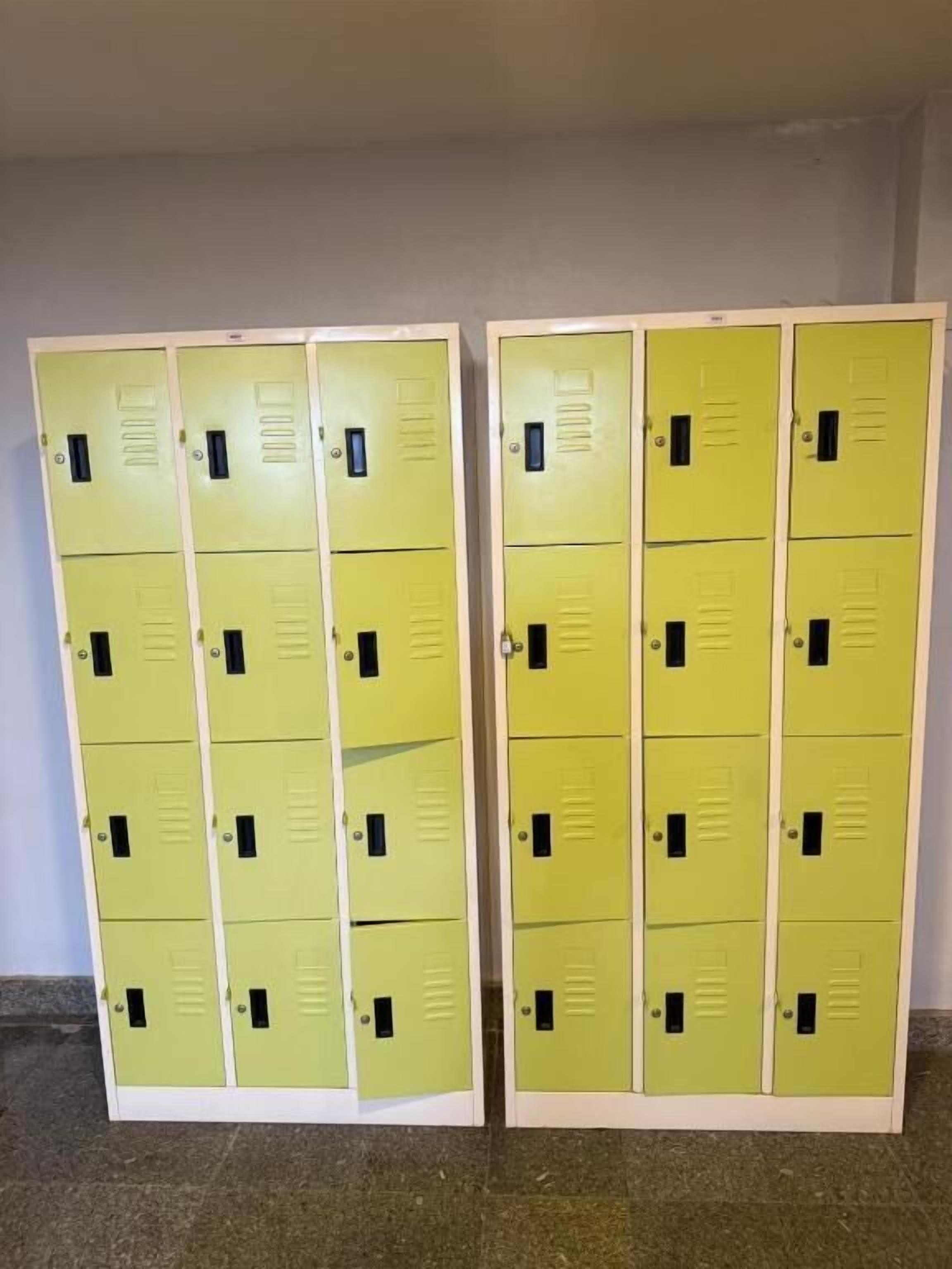 Quatro armários amarelos em sequência, com molduras brancas, cada um com vários compartimentos e uma pequena alça.