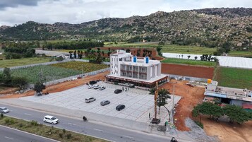 Um edifício moderno com telhado plano e ampla área de estacionamento.