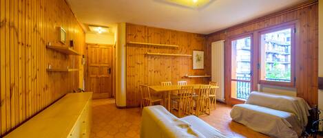 Quarto de madeira com uma cama, uma mesa e cadeiras.