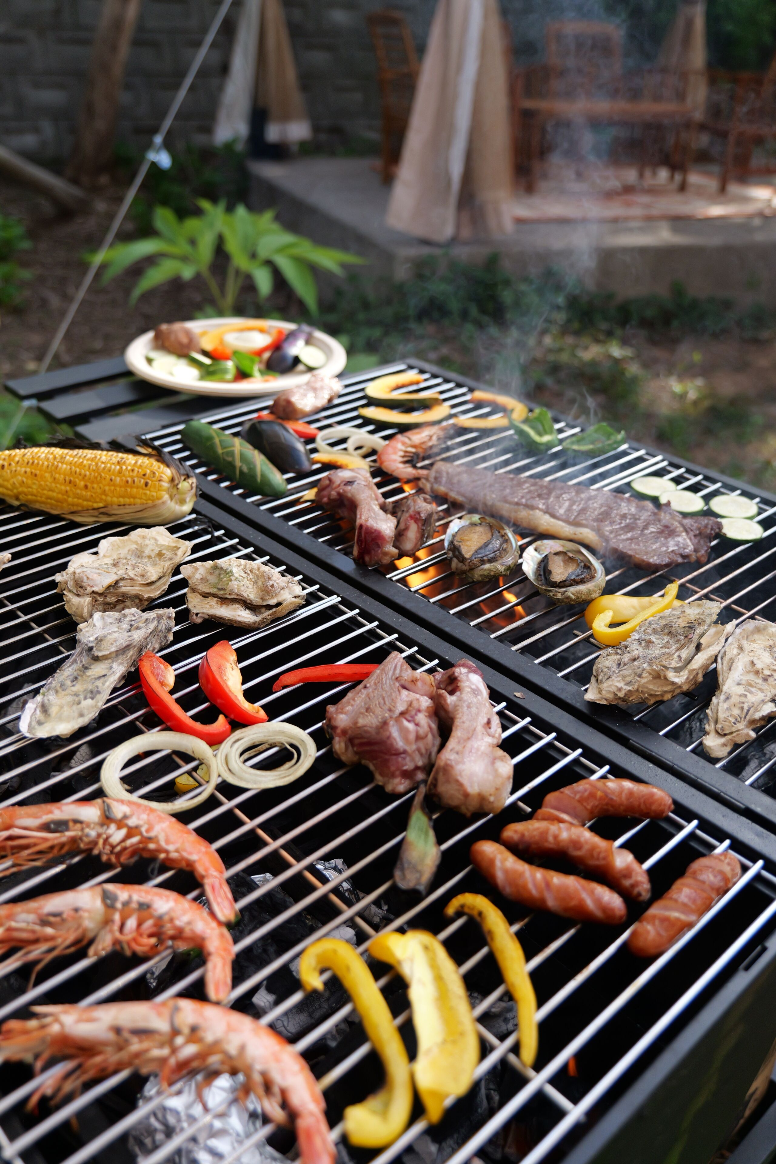 Uma churrasqueira com diversos tipos de carne e legumes.