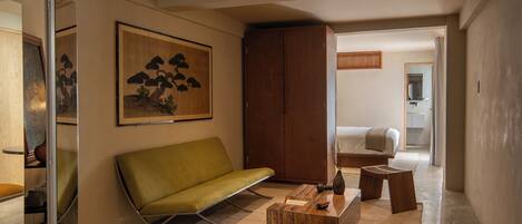Uma sala de estar moderna com um sofá verde, mesa de centro de madeira e um quadro na parede.