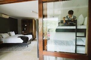 Quarto com beliche, guarda-roupa de madeira e uma janela grande.