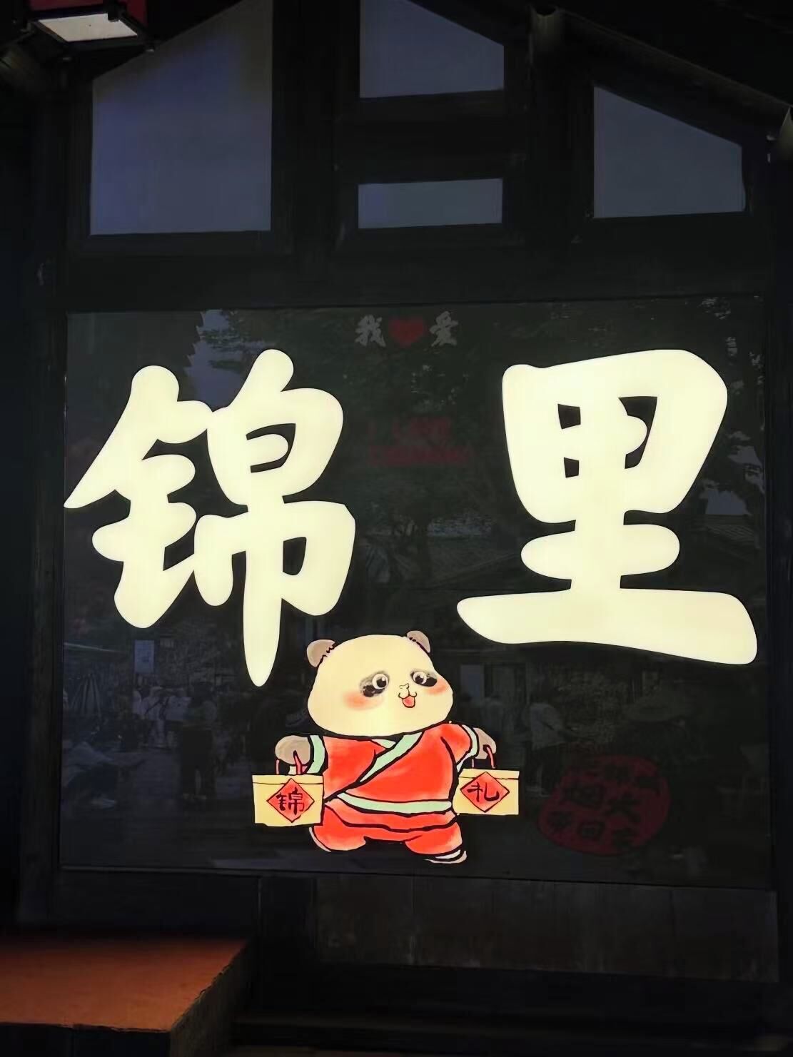 Um sinal com grandes caracteres chineses e um panda-caricatura.