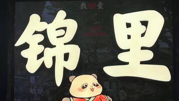 Um sinal com grandes caracteres chineses e um panda-caricatura.