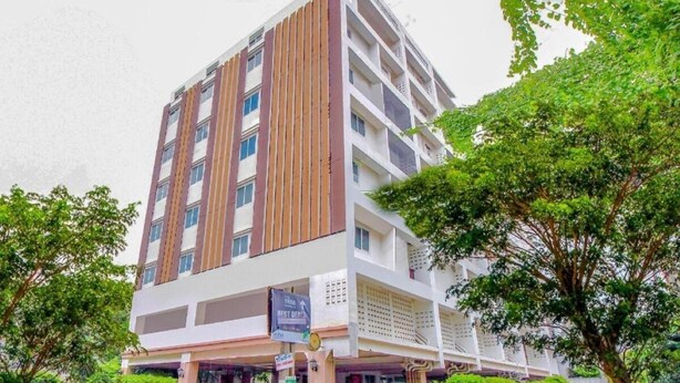 Hotel de vários andares com design moderno, destacando um painel vertical de madeira na fachada.