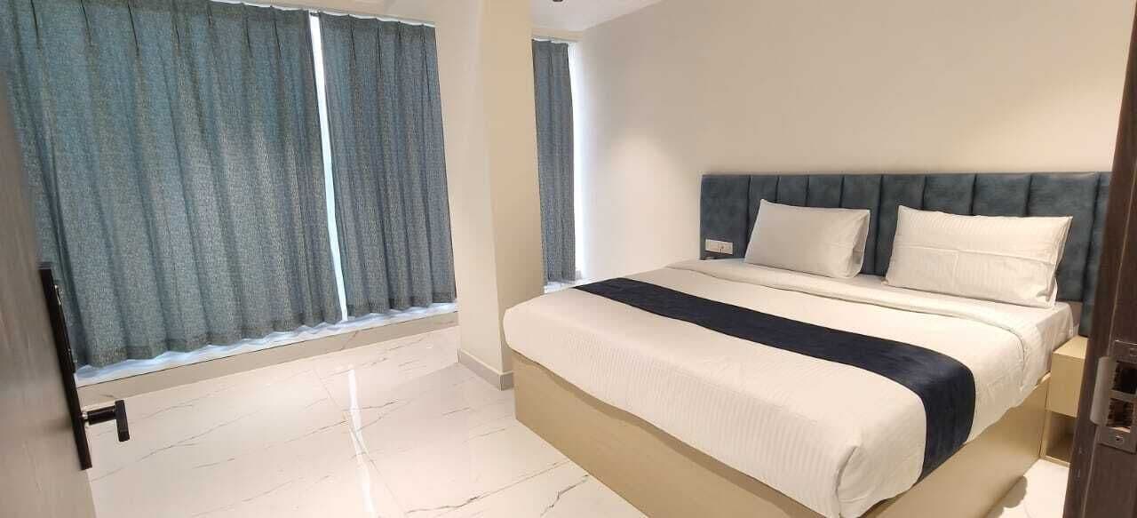 Quarto com cama, cortinas e porta.