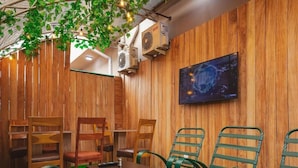 Uma sala de conferências com parede de madeira, uma tela grande e várias cadeiras.