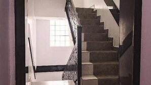 Uma escadaria com design geométrico, que dá acesso a um andar superior.