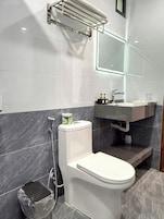 Uma casa de banho moderna com sanita, bidé e toucador.