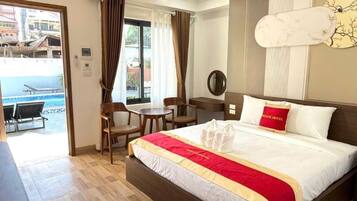 Quarto de hotel com uma cama, uma escrivaninha e vista para o mar.