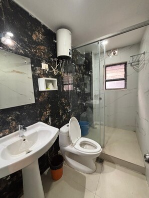 Chuveiro, toalhas de banho, sabonete, papel higiênico