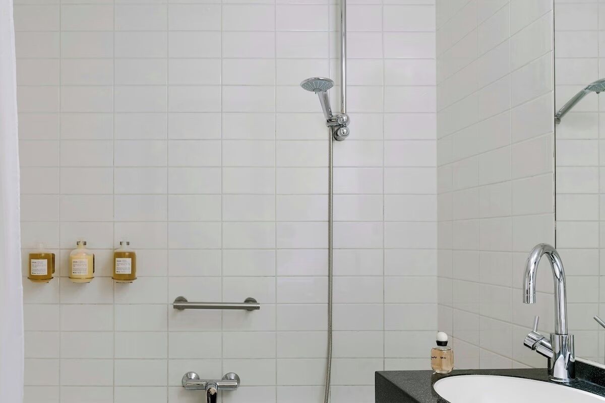 Um secador de cabelo, toalhas fornecidas, sabão, champô 