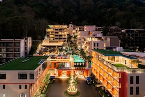 Hotel com vários andares, piscina ao ar livre e área central bem iluminada.