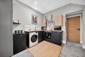 Um frigorífico, um micro-ondas, um forno, uma placa de cozinha 