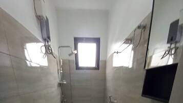 Casa de banho com paredes em azulejo, uma janela e um espelho.
