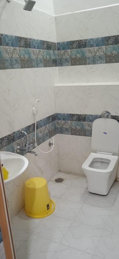 Um banheiro pequeno com vaso sanitário, pia e chuveiro.
