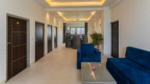 Um lobby moderno com balcão de recepção, área de estar e vista para o interior do edifício.